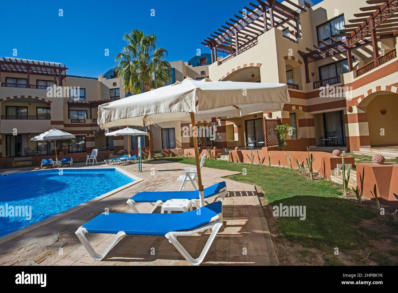 Swimming pool with buildings and sun loungers at a luxury tropical ...