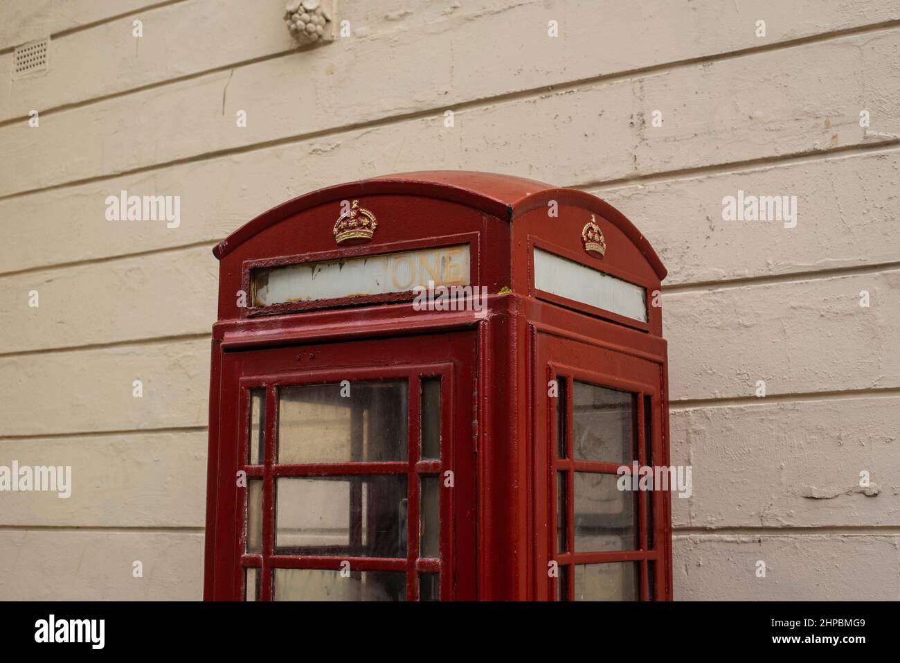 a traditional telephone cabin in England with red painting and crown ...
