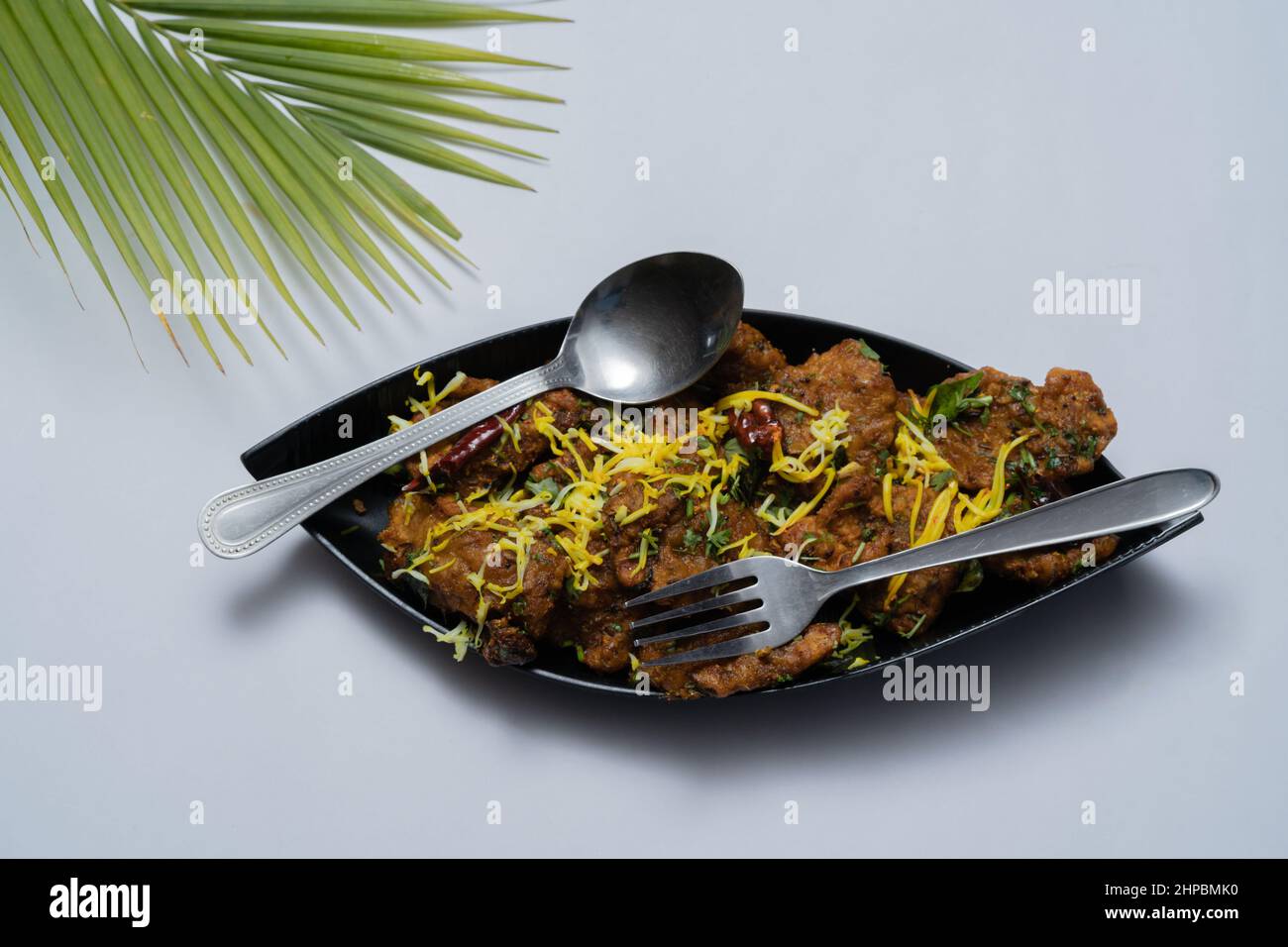 Close-up shot of a Chicken Tawa in the black plate on the grey ...