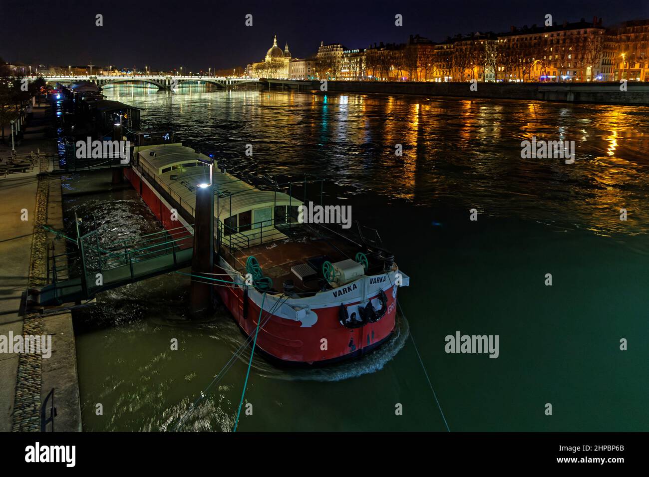 LYON, FRANCE, February 19, 2022 : A barge on Rhone river at night with ...