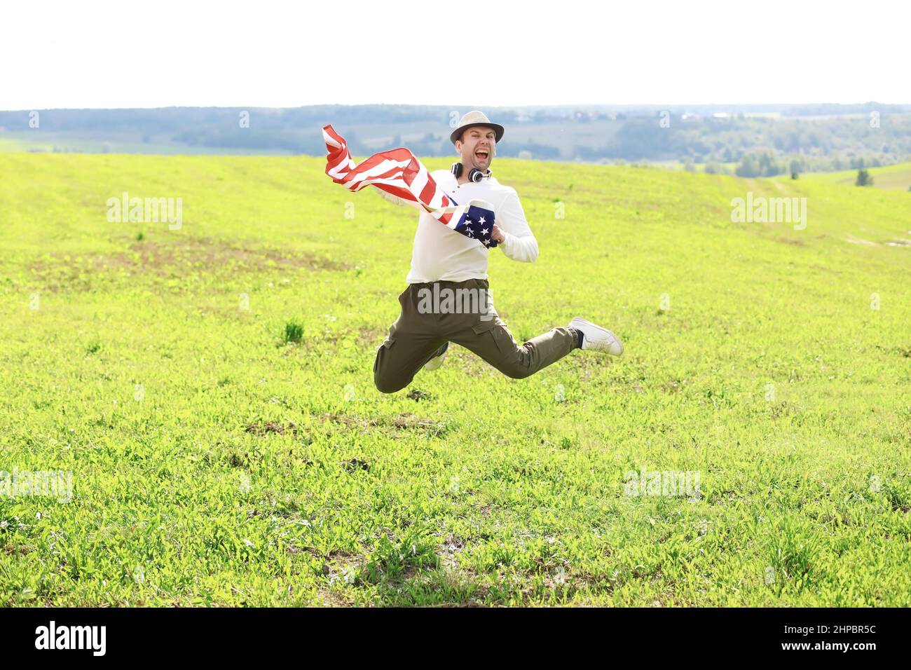 Man waving American flag standing in farm agricultural field , holidays ...