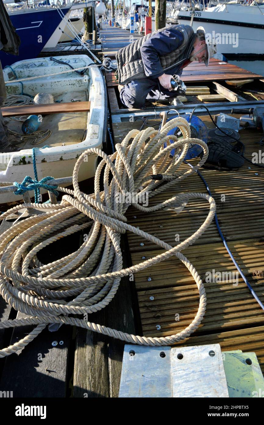 solitary man working on mooring pontoon at yacht club Stock Photo - Alamy