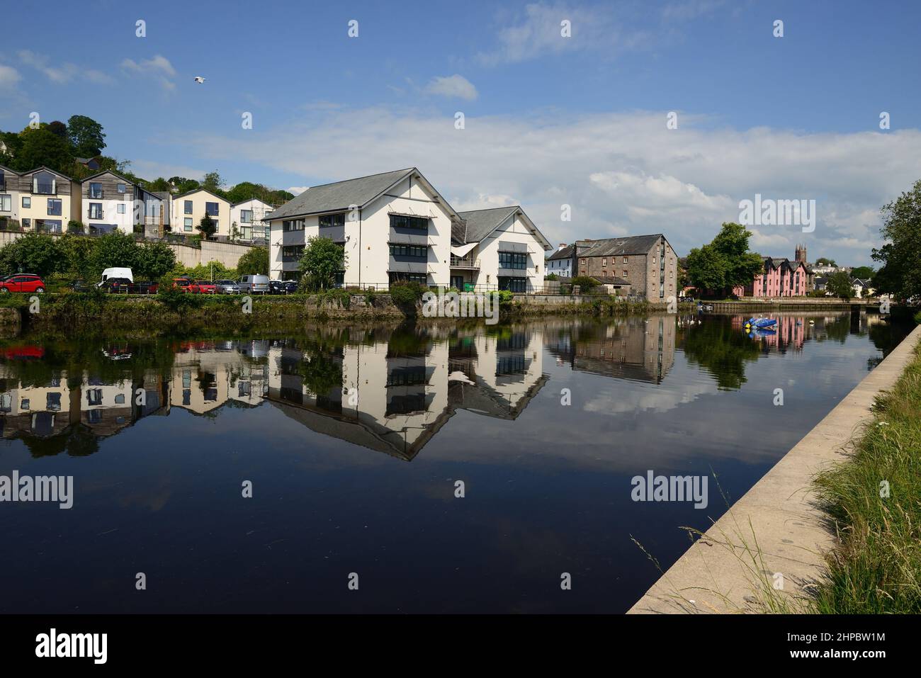 Riverside properties reflected in the river Dart at Totnes, South Devon ...