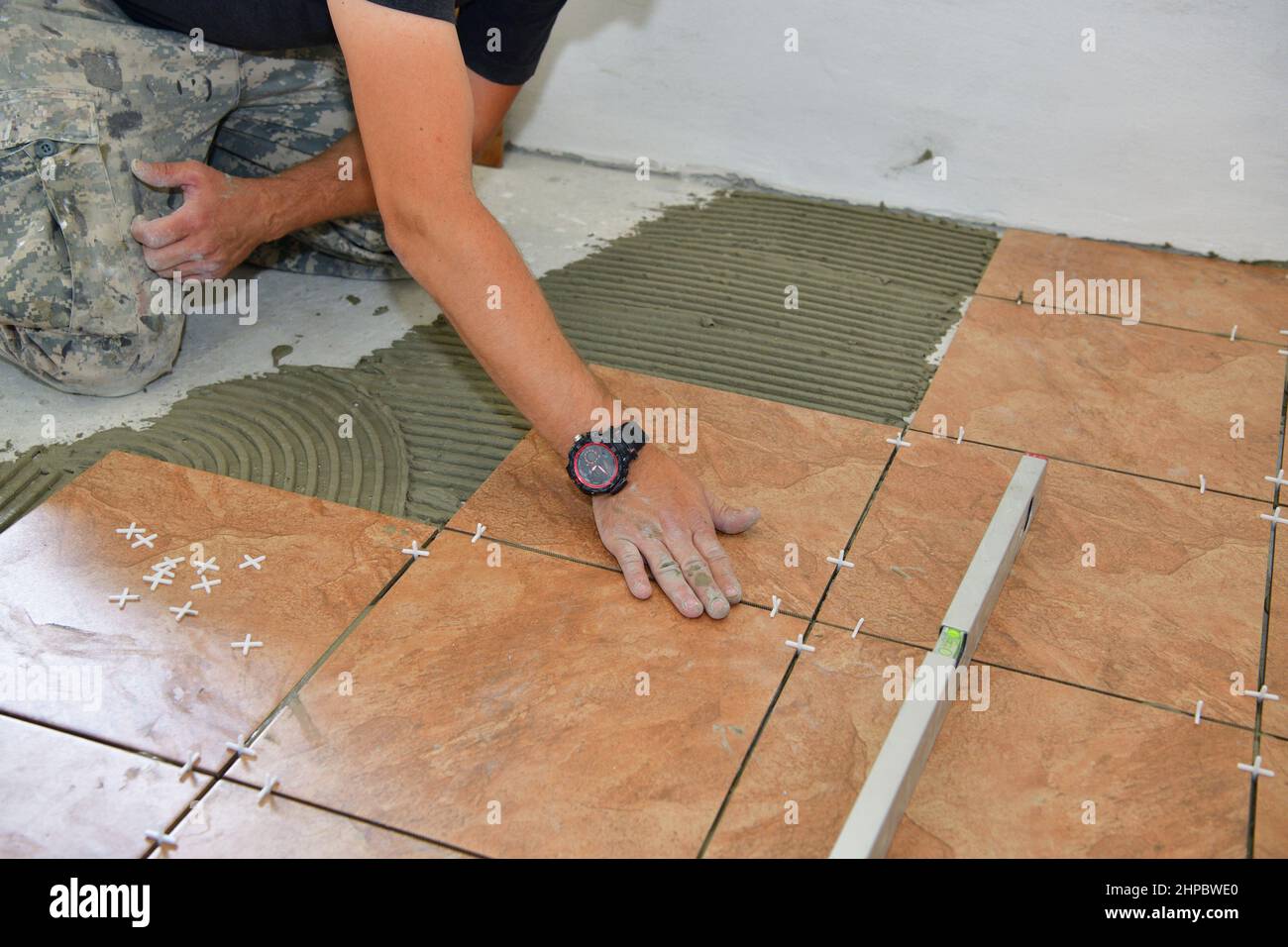 Laying tiles on the floor of the room on the construction site Stock ...