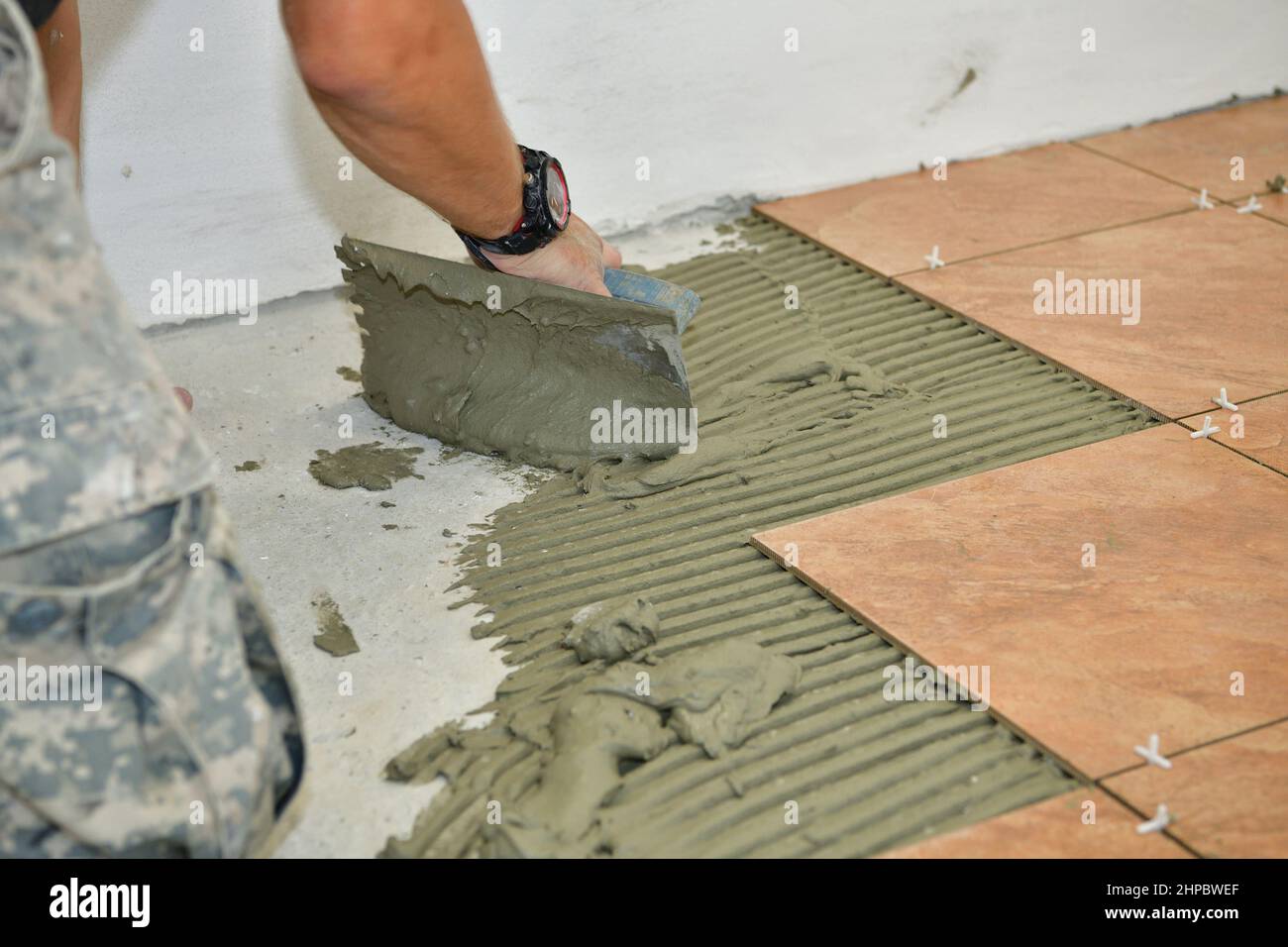 Laying tiles on the floor of the room on the construction site Stock ...