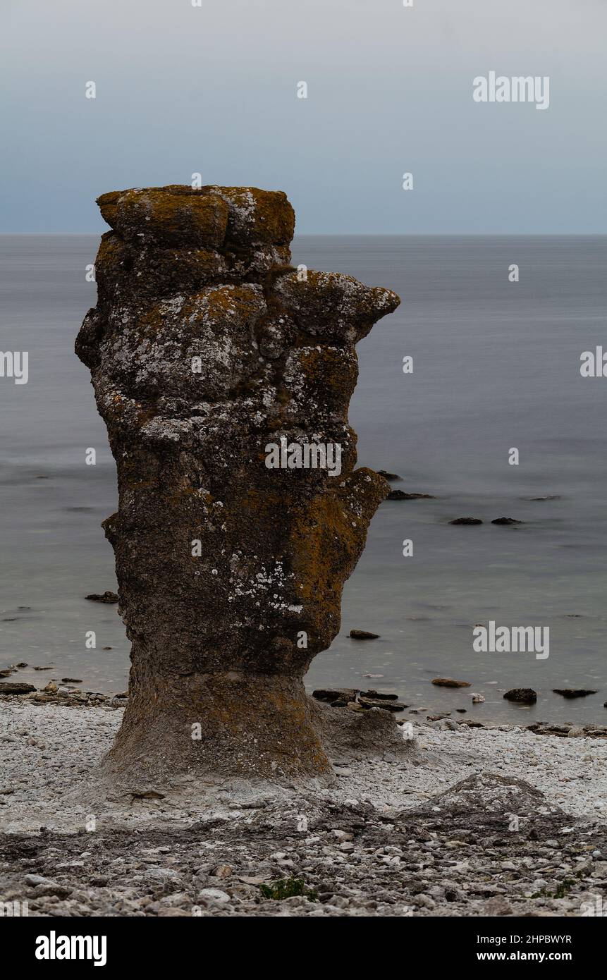 A tall rock formation resembling a face on a beach at Langhammers ...