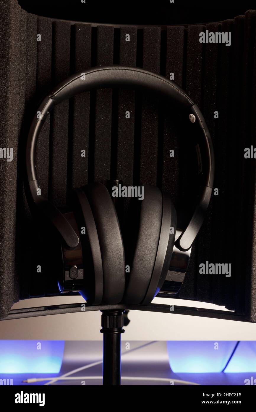 Modern wireless headphones with travel bag resting on black background ...