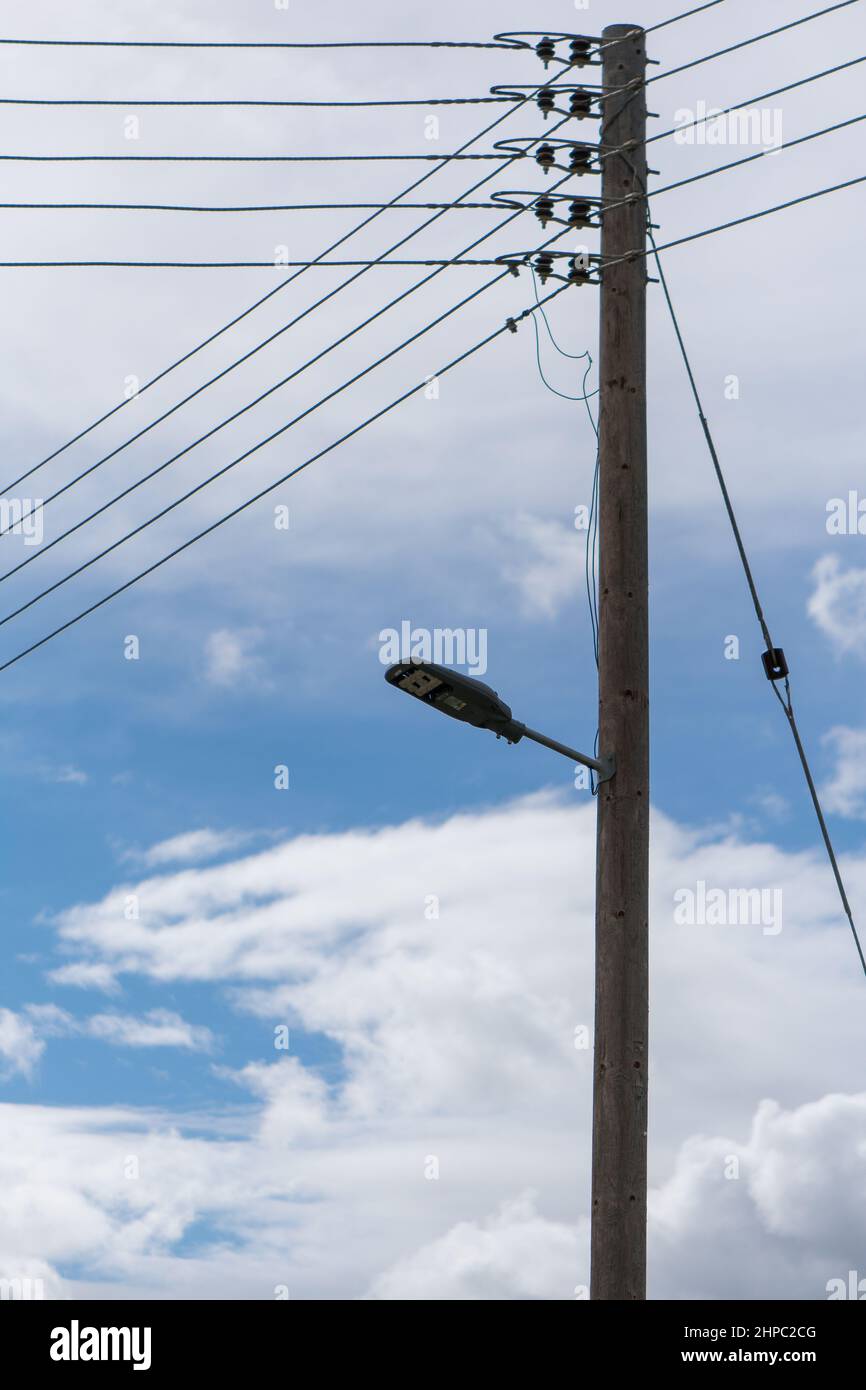 Vertical shot of electrical cable lines and street light with a sky ...