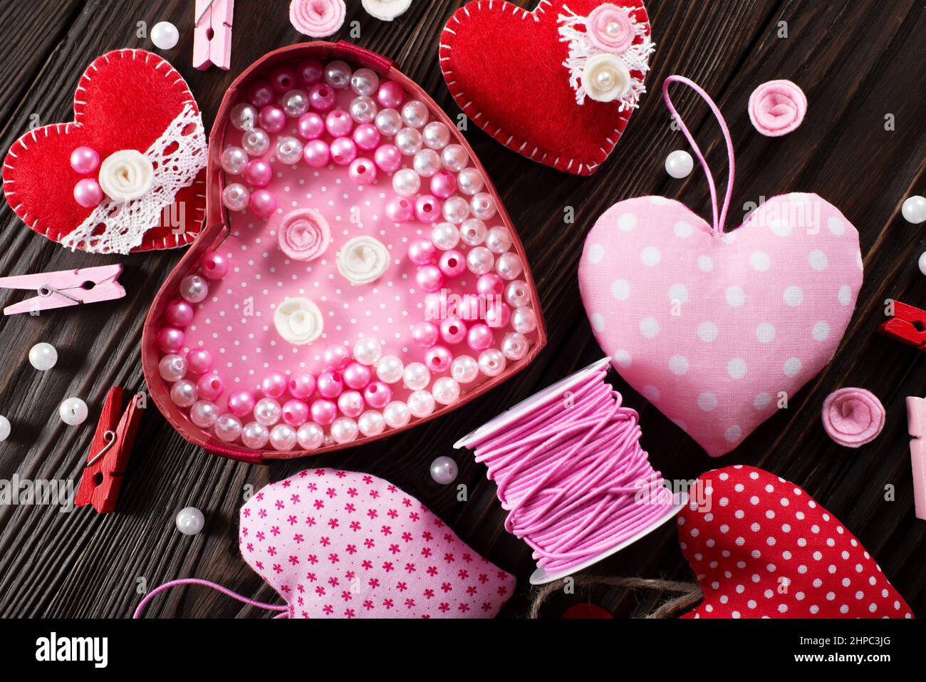 DIY Valentine hearts laundry pins and sewing spool on wooden table flat ...