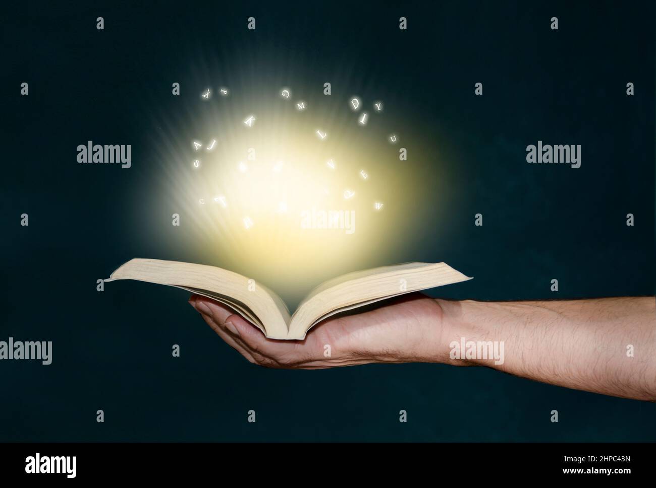 Man holding magic book with hand Stock Photo - Alamy
