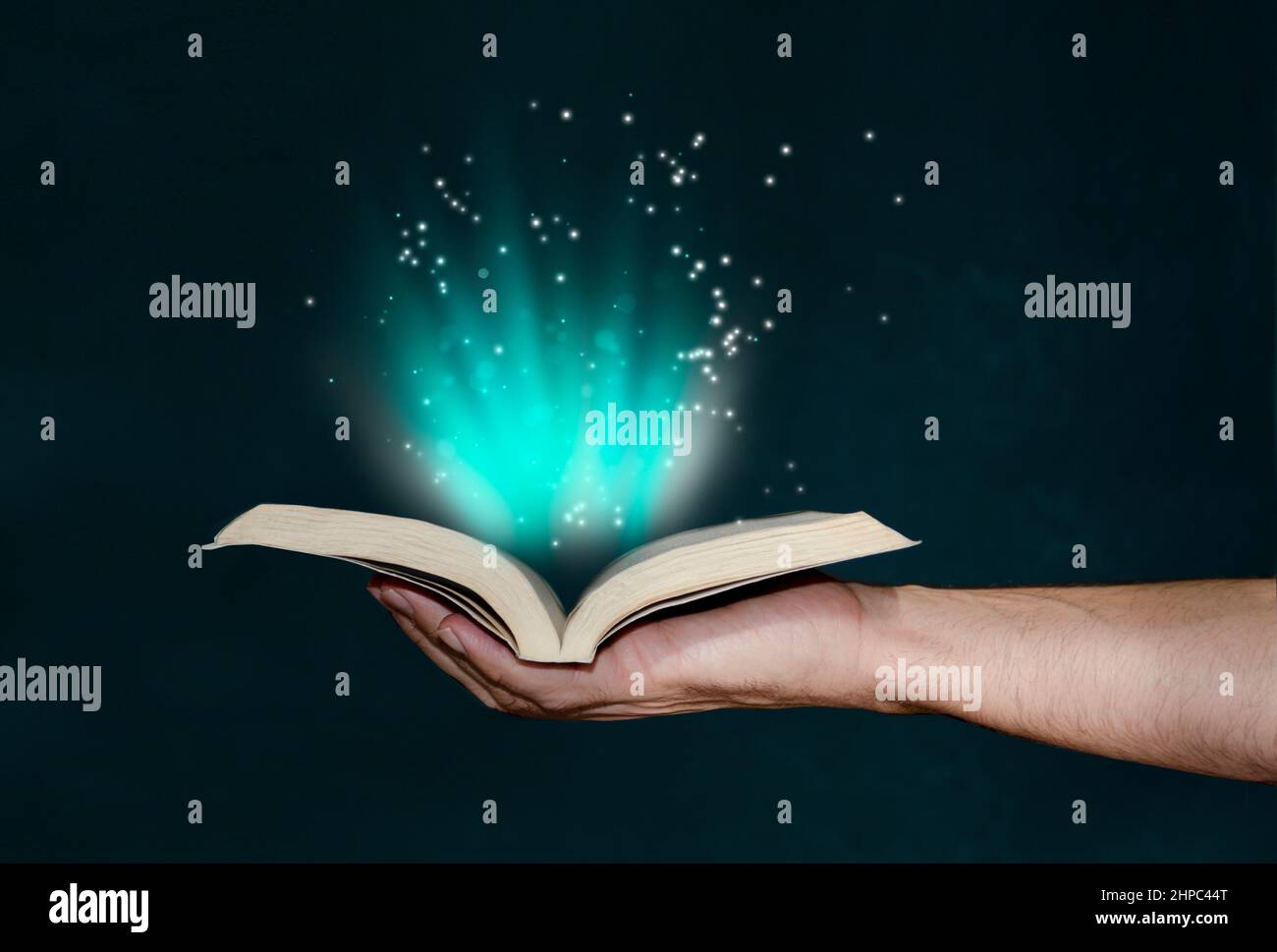 Man holding magic book with hand Stock Photo - Alamy