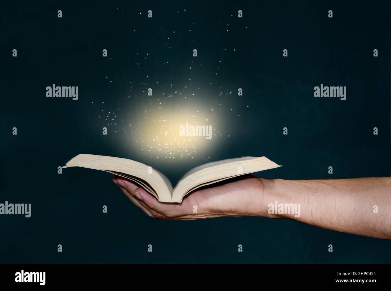 Man holding magic book with hand Stock Photo - Alamy