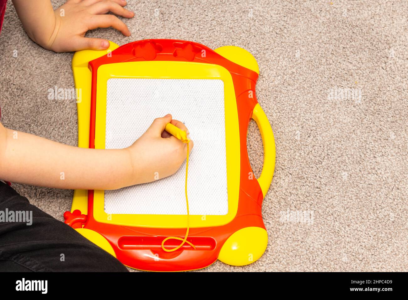 Child's hand drawing on educational drawing board that is magnetic and ...