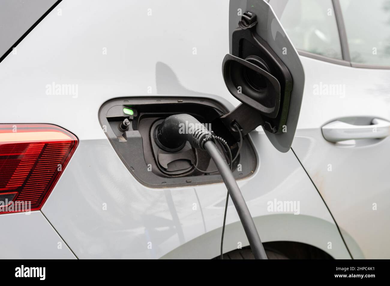 Electric car charging at plug in charge station in a public car park in ...