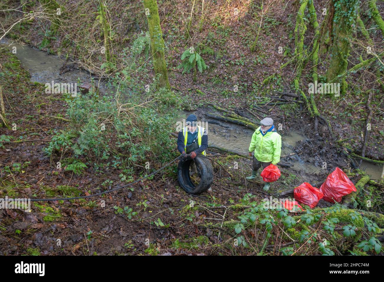 Volunteers and contractor removing flytipped material from stream Stock ...