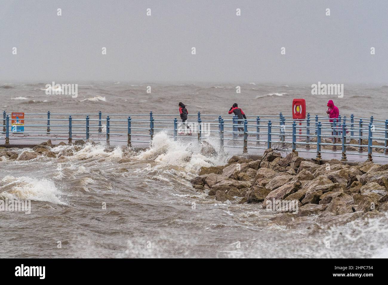 People walk on promenade in stormy weather Stock Photo - Alamy