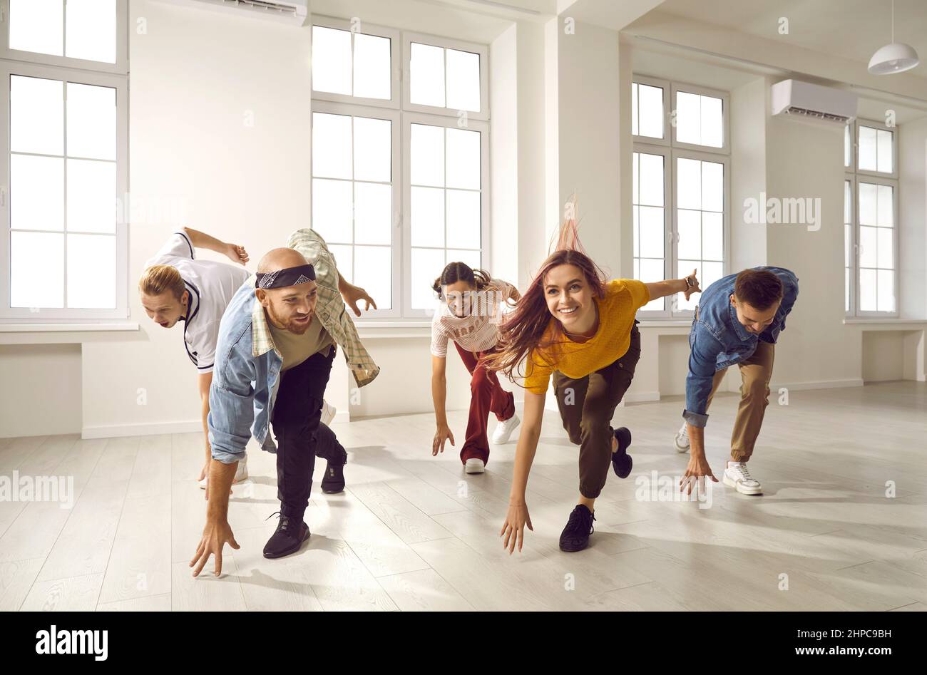 Group of happy young male and female contemporary dancers dancing in a ...