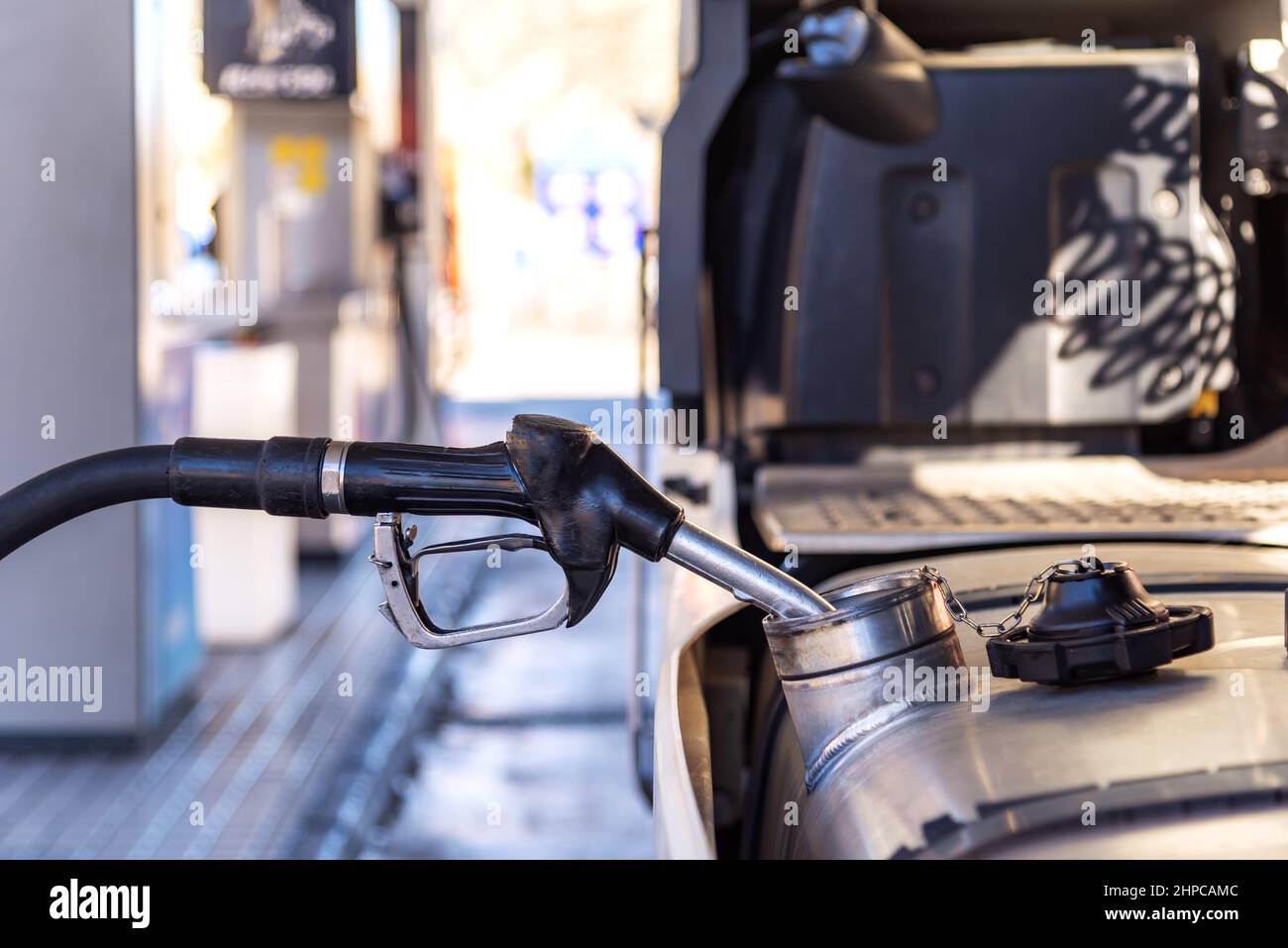 Truck refueling diesel at a highway gas station, close-up of the nozzle ...