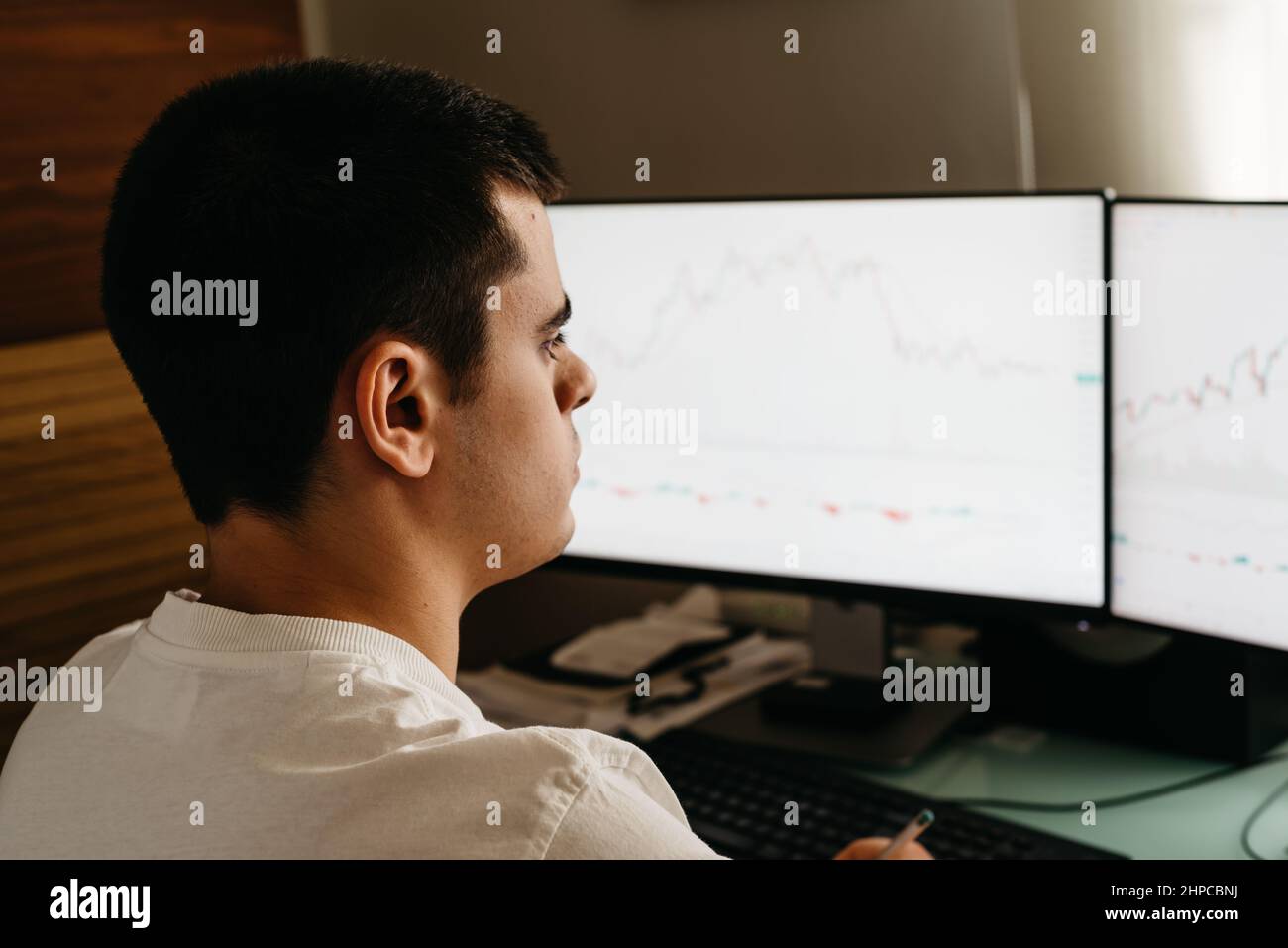 Busy working day at home. Side view of successful young trader in ...