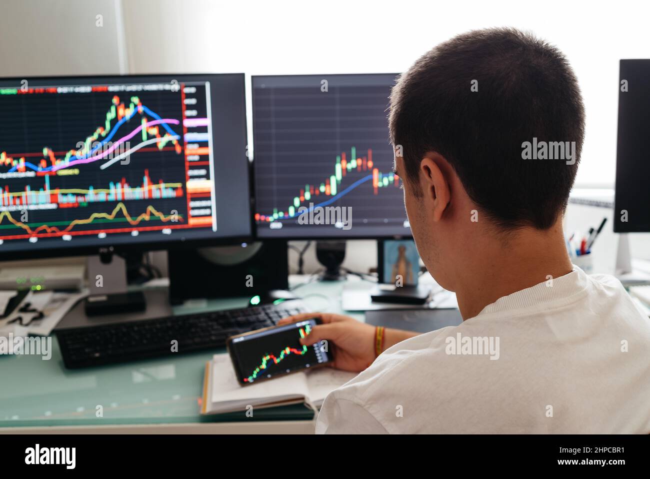 Busy working day at home. Side view of successful young trader in ...