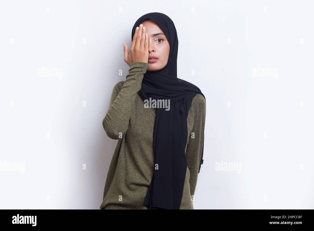 asian muslim woman covering one eye with hand Stock Photo - Alamy