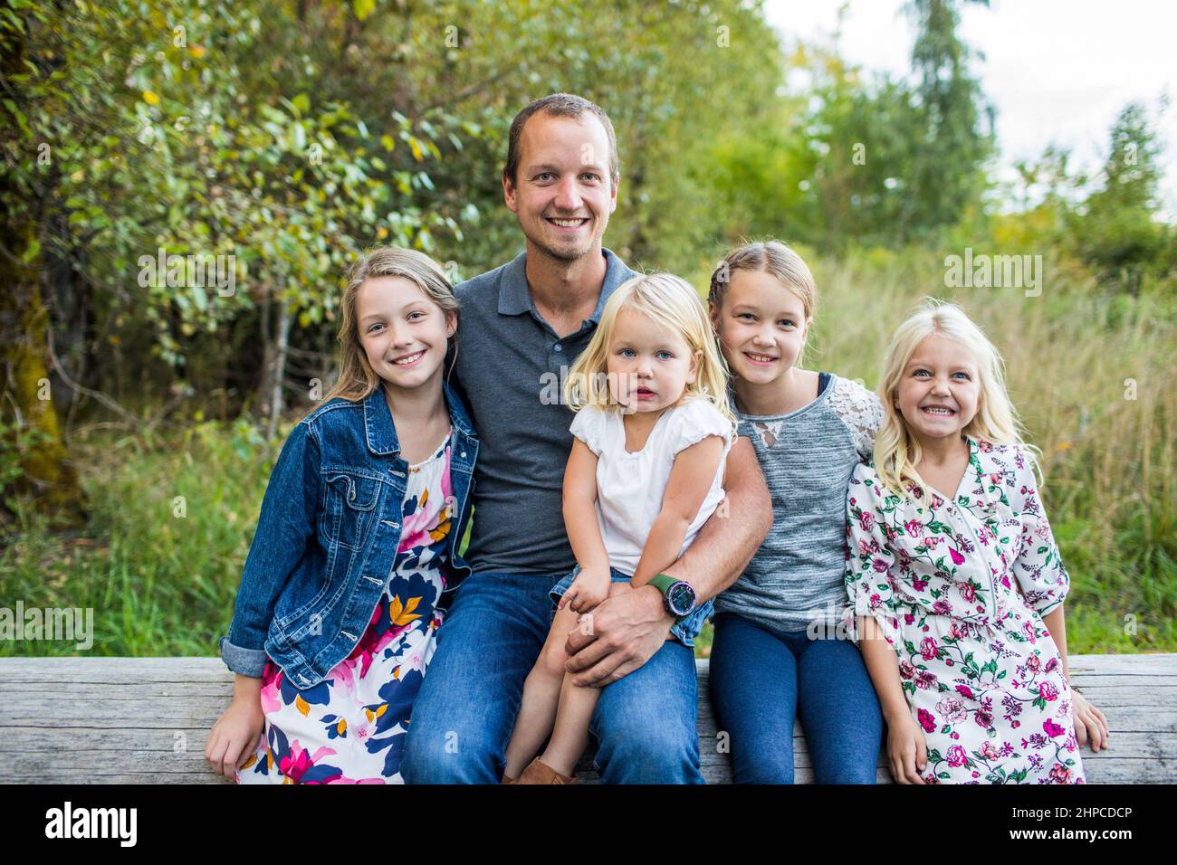 Portrait of father sitting with his four beautiful daughters Stock ...