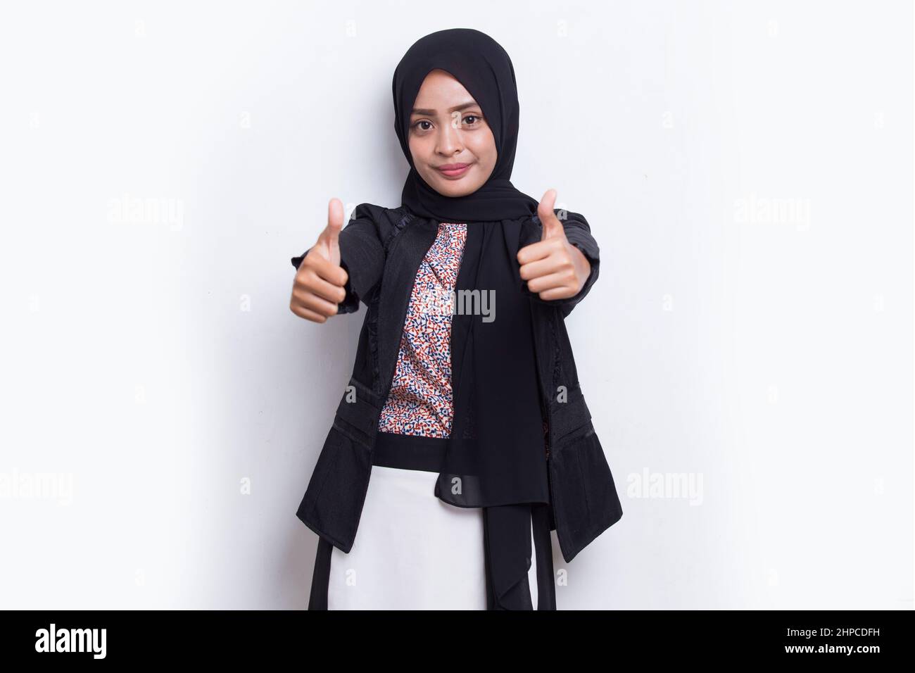 young asian beautiful muslim woman with ok sign gesture tumb up isolated on white background ...