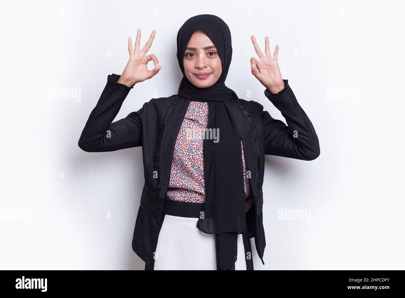 young asian beautiful muslim woman with ok sign gesture tumb up isolated on white background ...