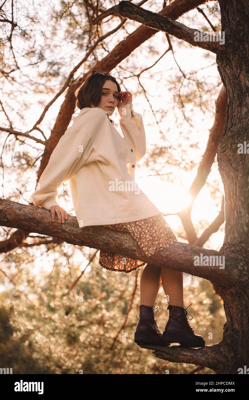 Girl sitting on branch of tree hi-res stock photography and images - Alamy