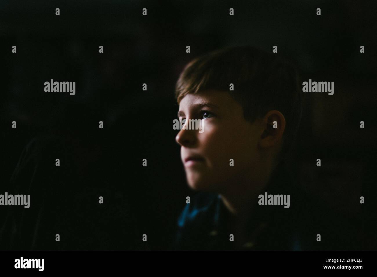 Boy with dramatic light on face and in eyes Stock Photo - Alamy