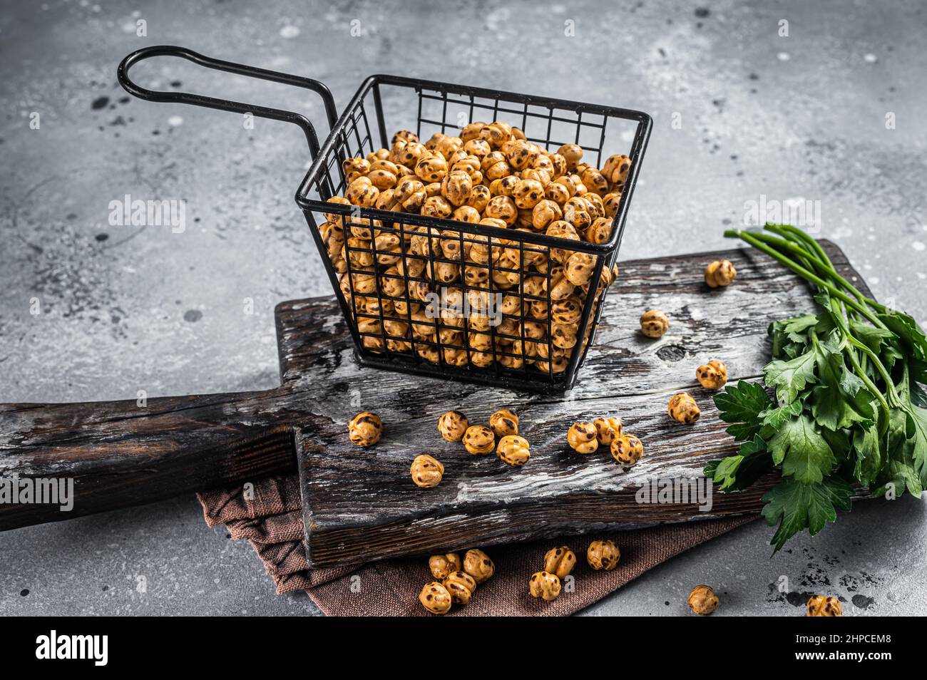 Healthy snack roasted spicy chickpeas in a basket. Gray background. Top ...