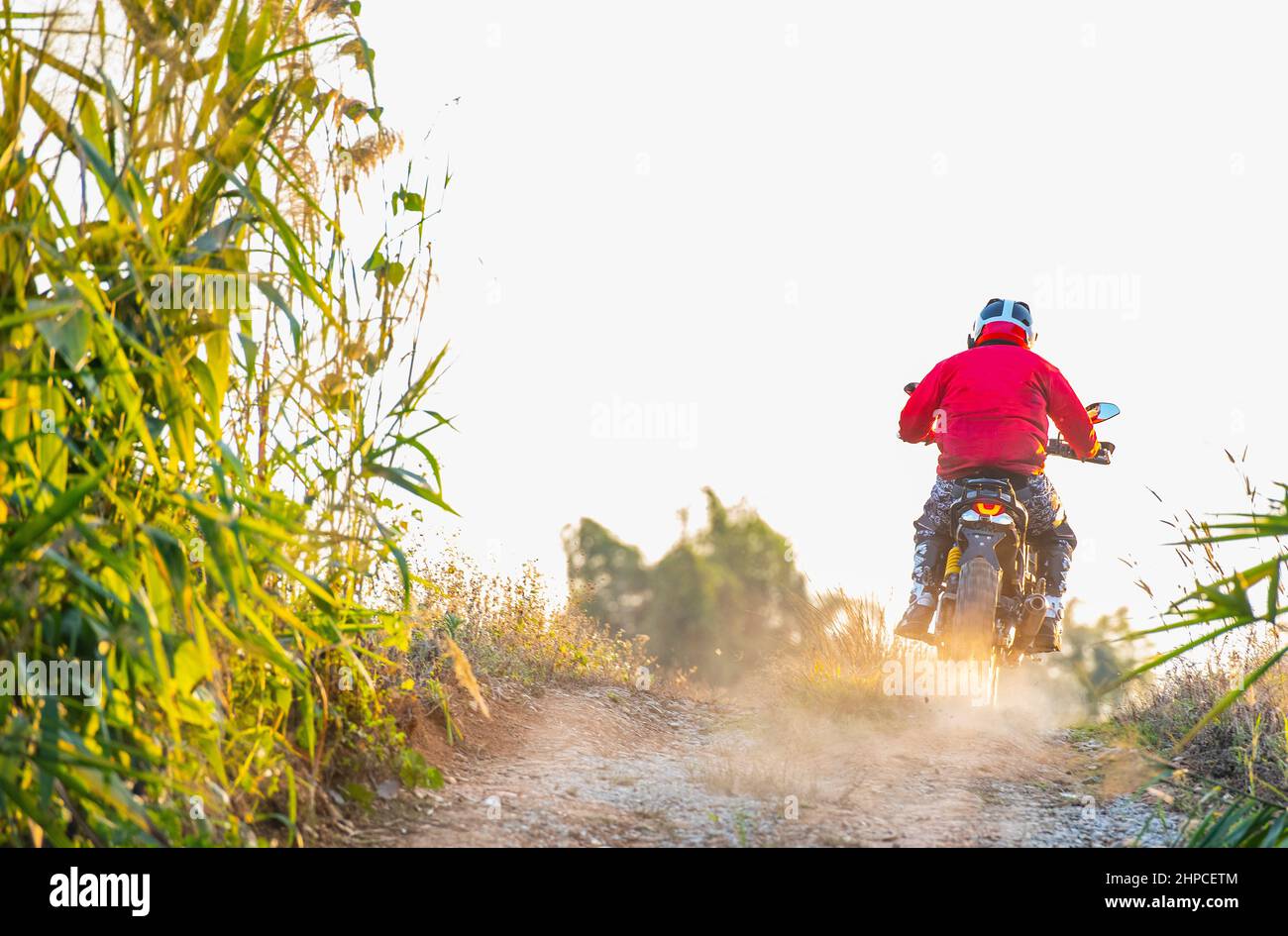 Man riding his scrambler type motorcycle on rugged terrain in Thailand ...
