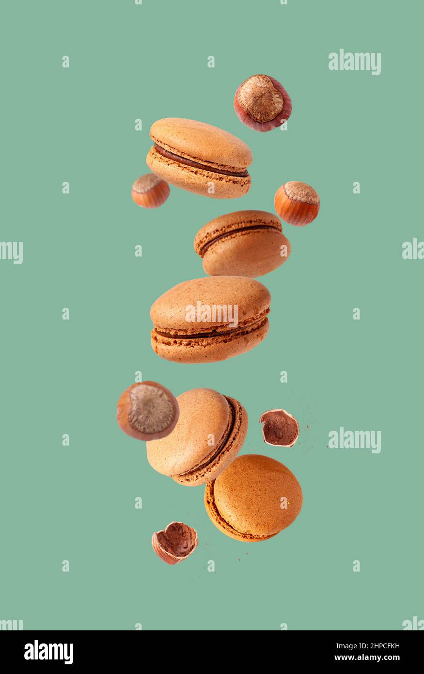 nutty macaroons and hazelnuts with crumbs flying on a green back Stock ...