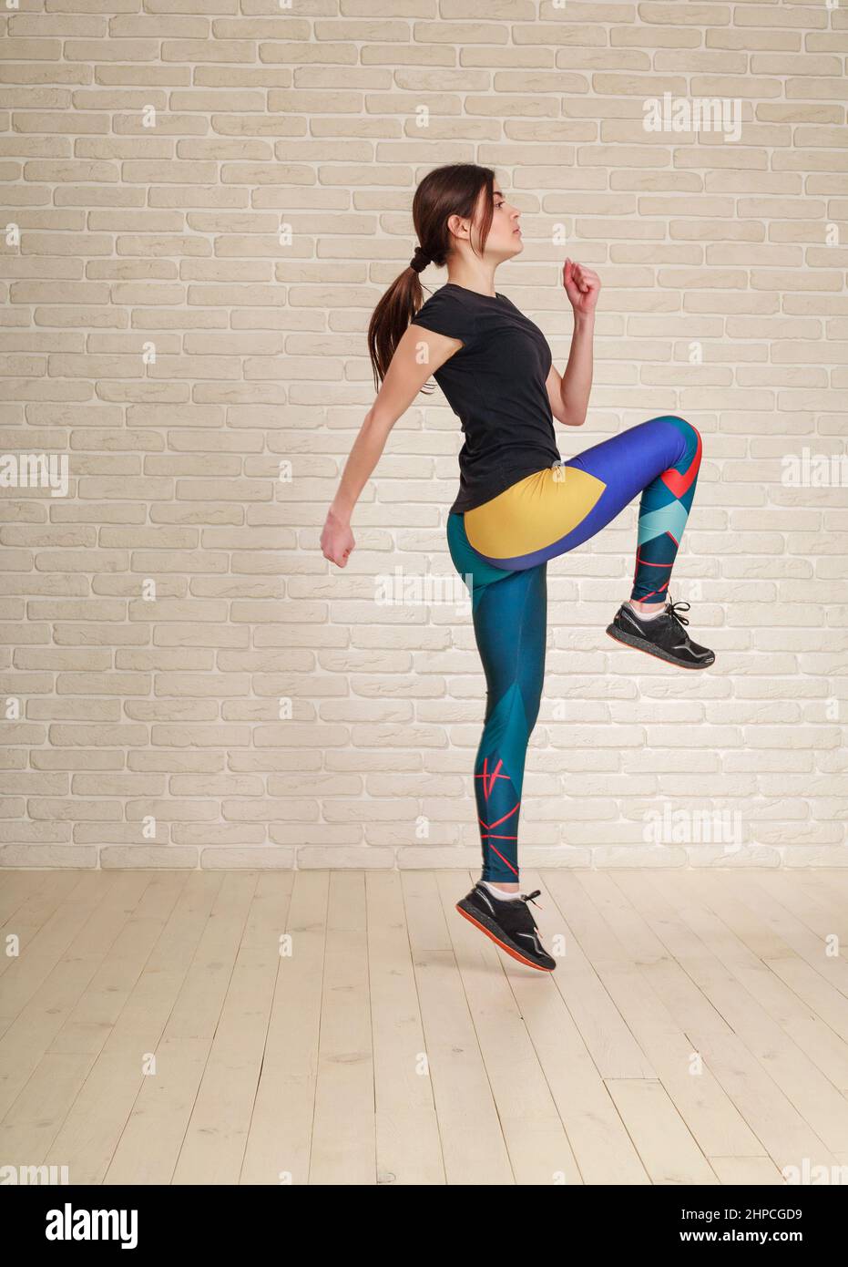 Active athletic slim young woman runner doing stretching exercises ...