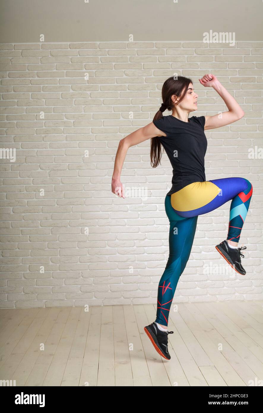 Active athletic slim young woman runner doing stretching exercises ...