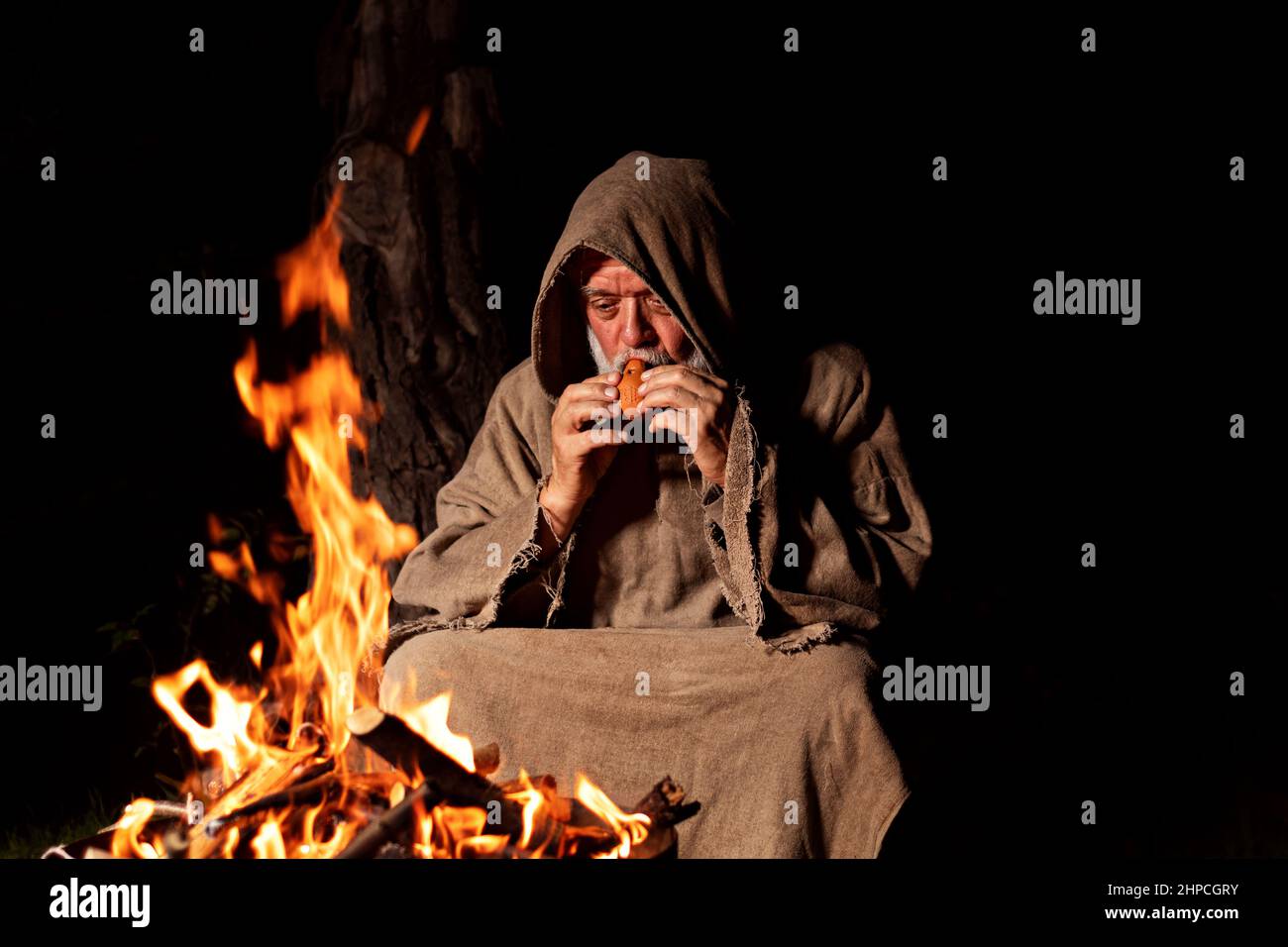 Medieval shepherd with flute by the campfire Stock Photo - Alamy