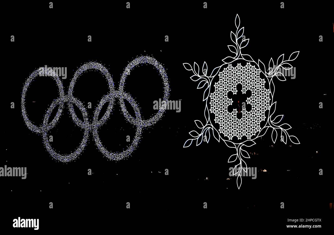 Beijing, China. 20th Feb, 2022. The risen Olympic rings pass by the giant snowflake cauldron ...