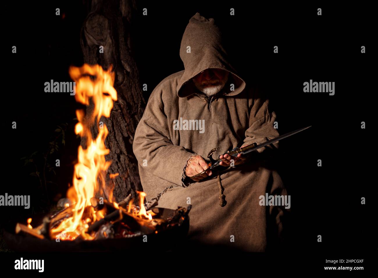 Medieval poor fighter with sword at the campfire Stock Photo - Alamy