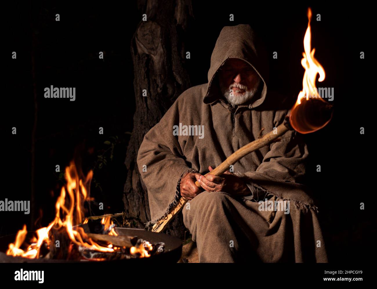 Old medieval monk by the fire with torch Stock Photo - Alamy