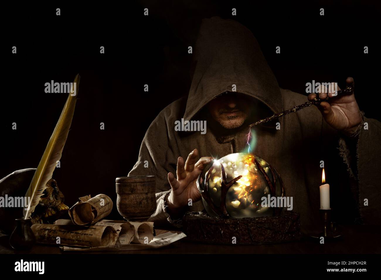 medieval witcher conjures up with a glass ball Stock Photo - Alamy