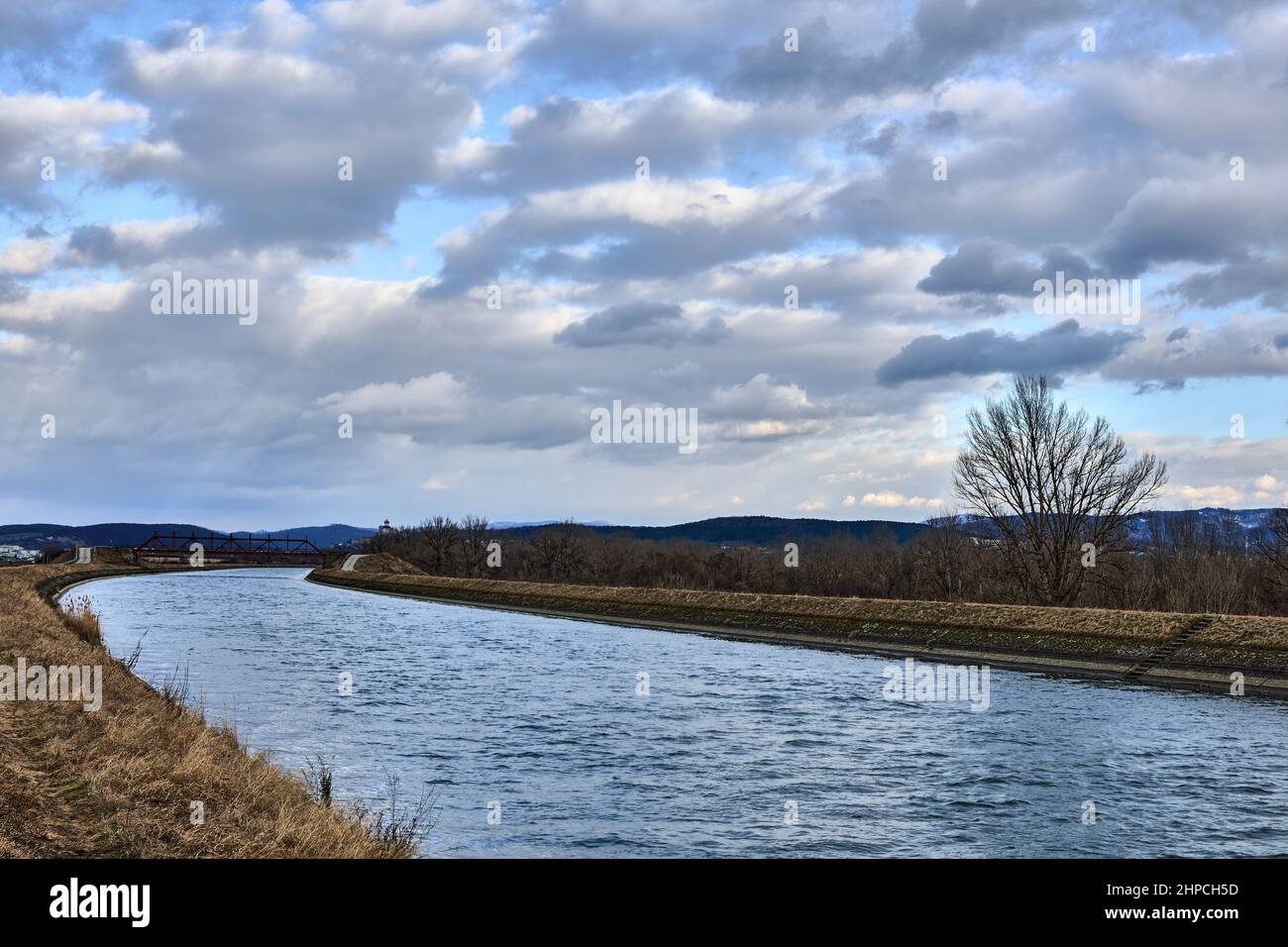 Landscape with waterway and dramatic cloudy sky, gray white clouds ...
