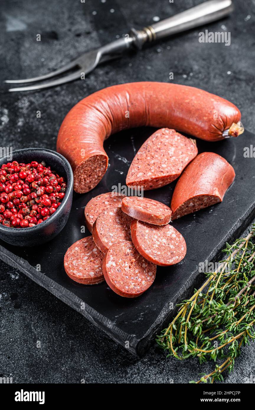 Turkish Sliced Sucuk meat sausage on a marble board with thyme. Black ...