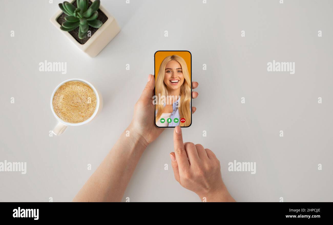 Woman using mobile app on smartphone for video chat with female friend ...
