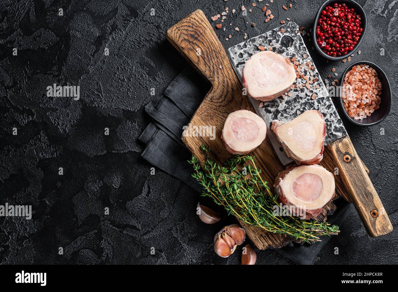 Uncooked Raw veal Marrow bones on butcher board with meat cleaver ...