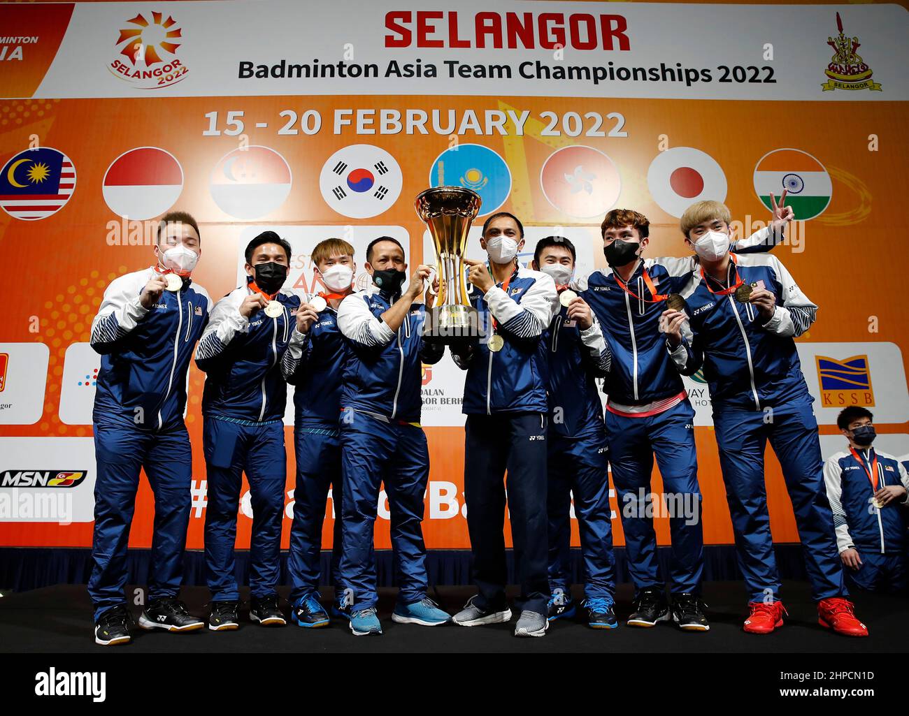 Players of team Malaysia with their winner trophy pose for photos on the podium at the Badminton ...