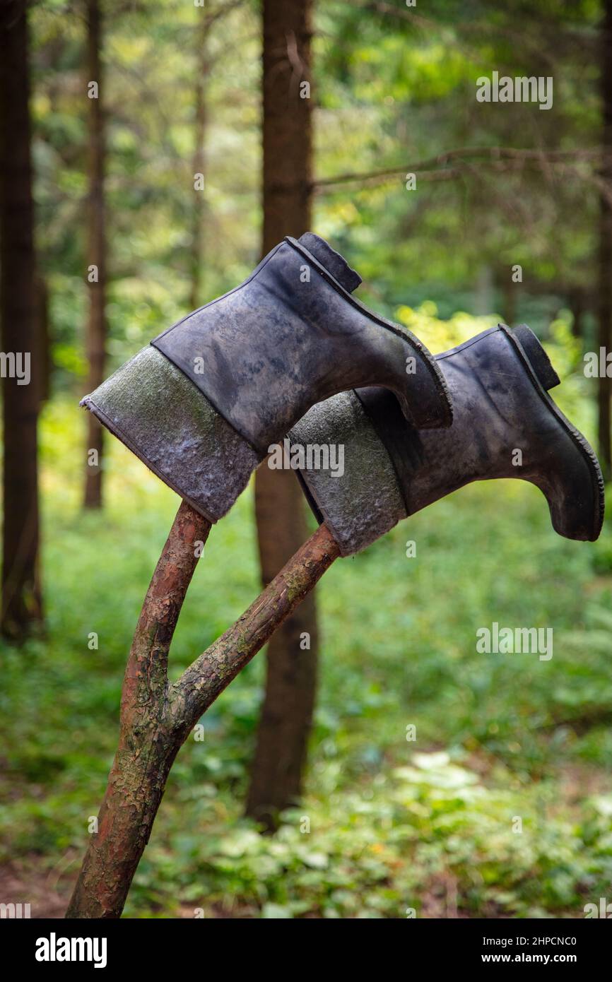 old rubber boots are hanging on a stick Stock Photo - Alamy