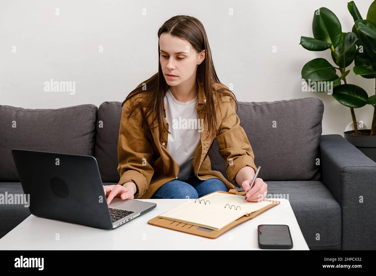 Focused young caucasian girl student studying virtual course, learning ...