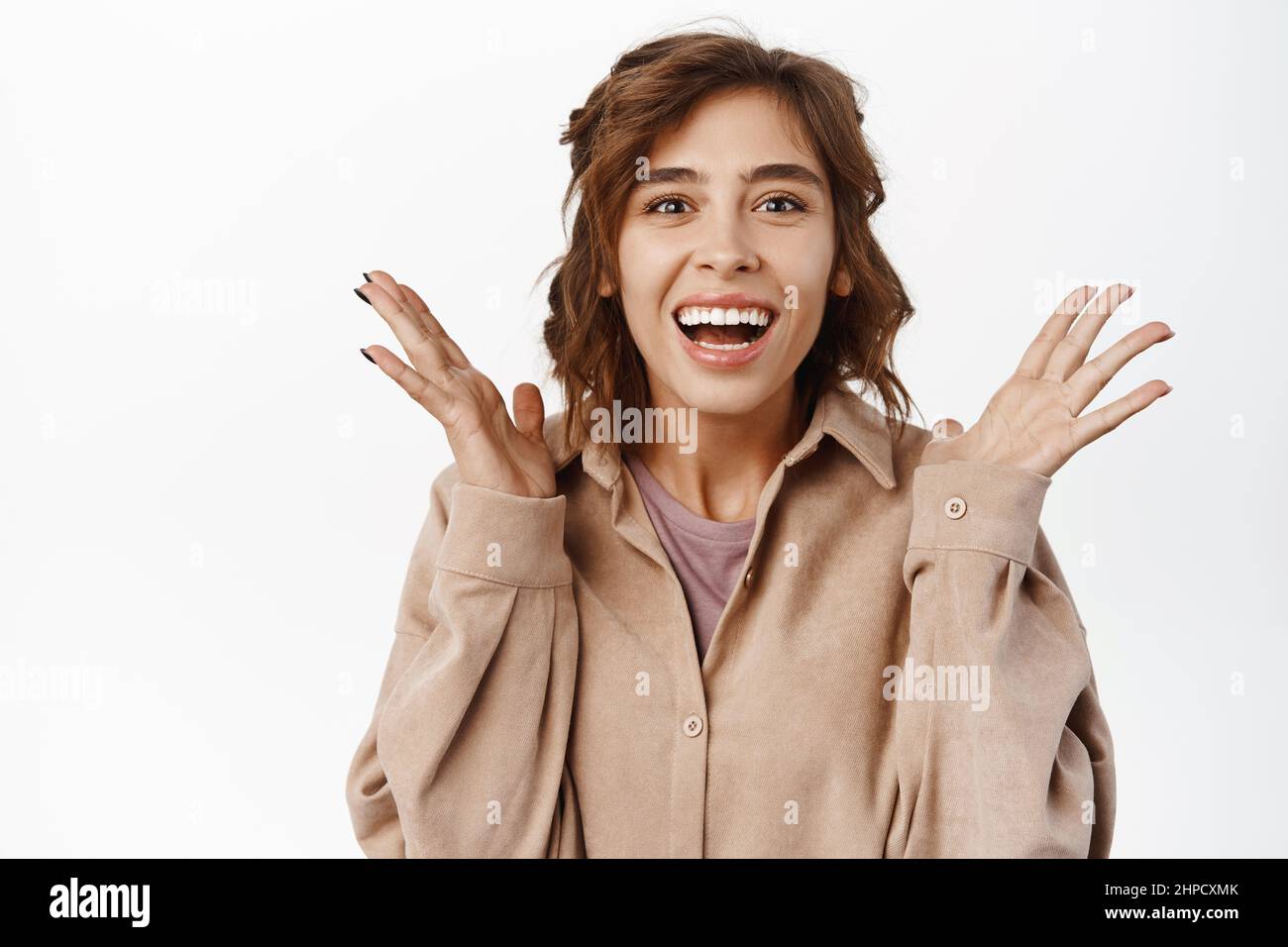 Excited young woman clap hands, looking with delight at admiration ...