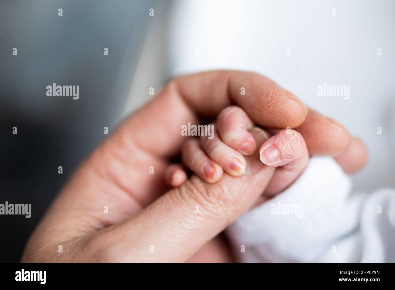 hand of newborn baby who has just been born holding the finger of his ...