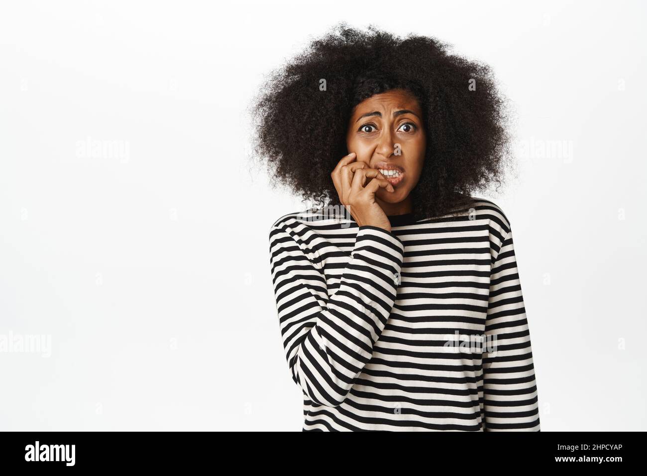 Insecure Black woman biting fingernails, looking scared, trembling fear ...